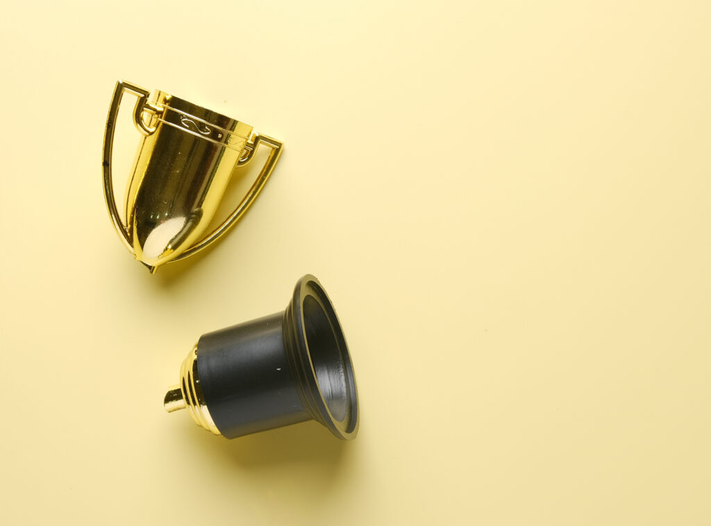 A picture of broken trophy on copyspace yellow background. Failu ...